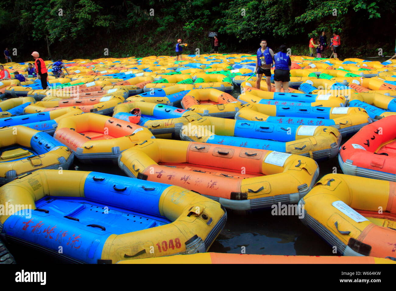 A crowd of tourists sitting on inflatable rafts jam Gulong Valley as ...