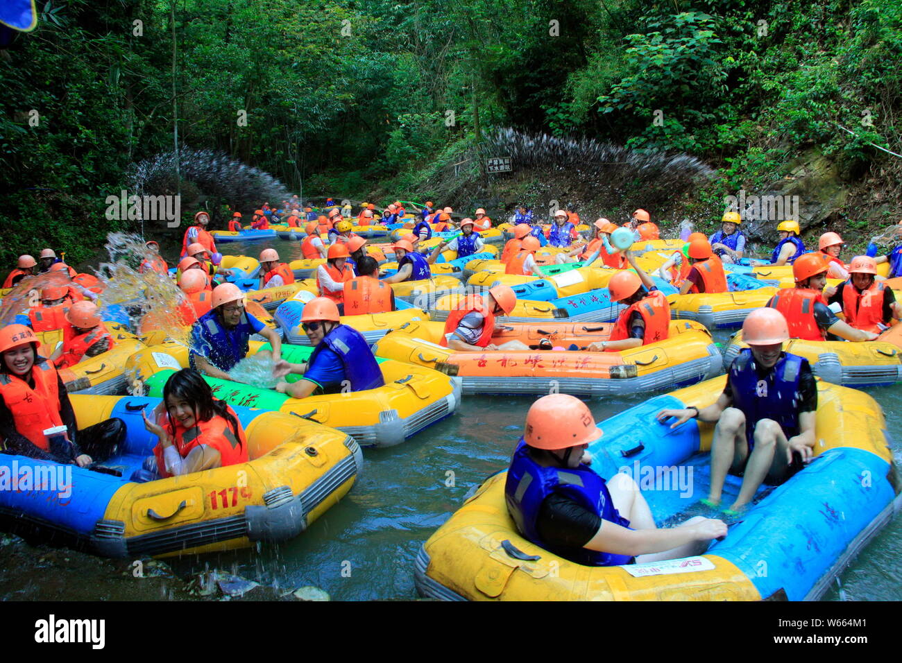 A crowd of tourists sitting on inflatable rafts jam Gulong Valley as ...