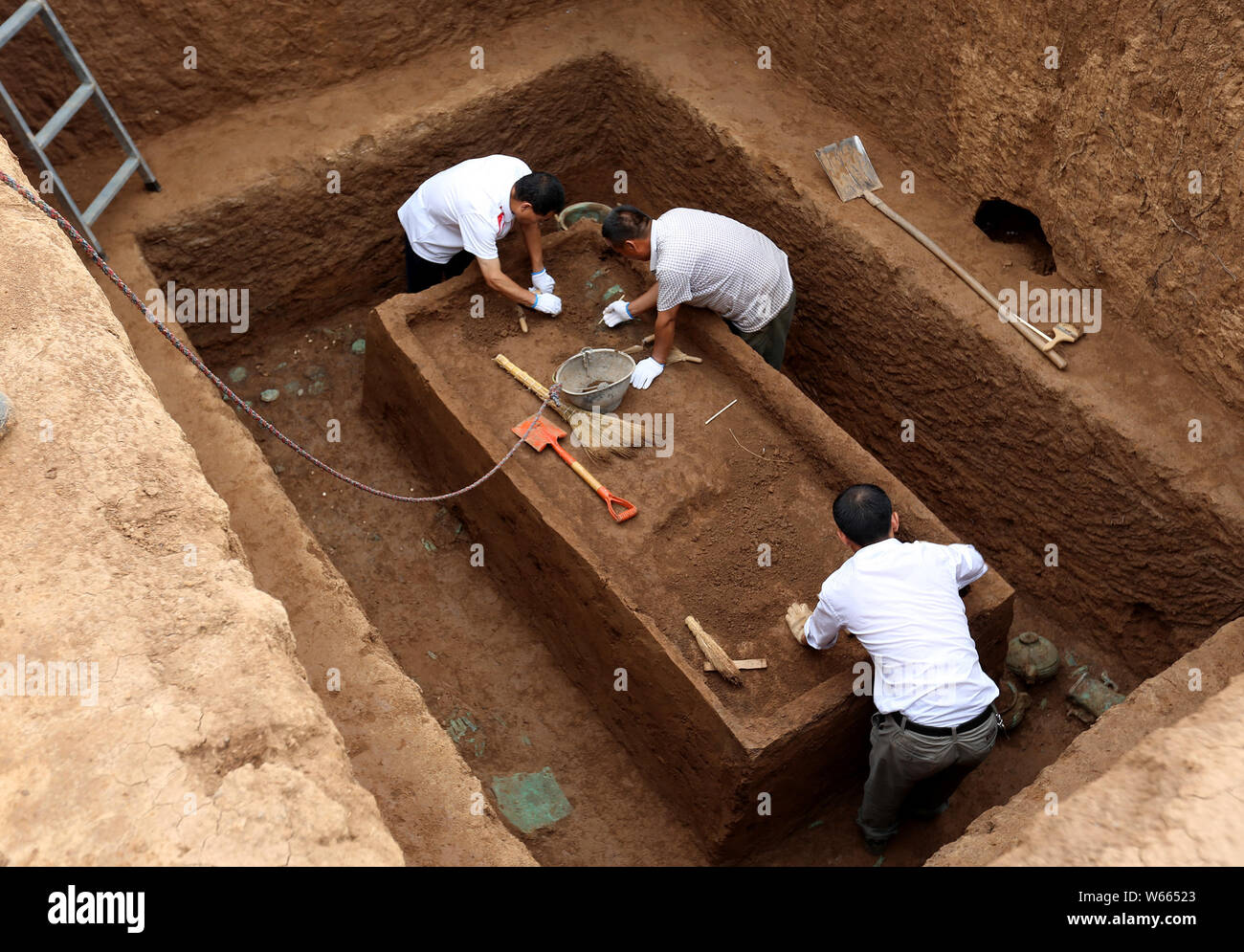 Chinese archaeologists excavate a tomb of the Shangshihe village tomb ...