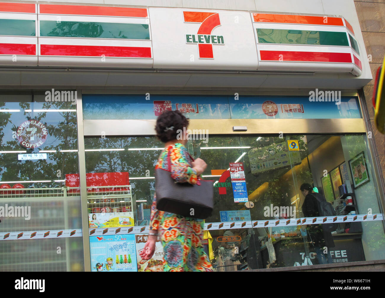 --FILE--A pedestrian walks past a 7-Eleven convenience store in ...