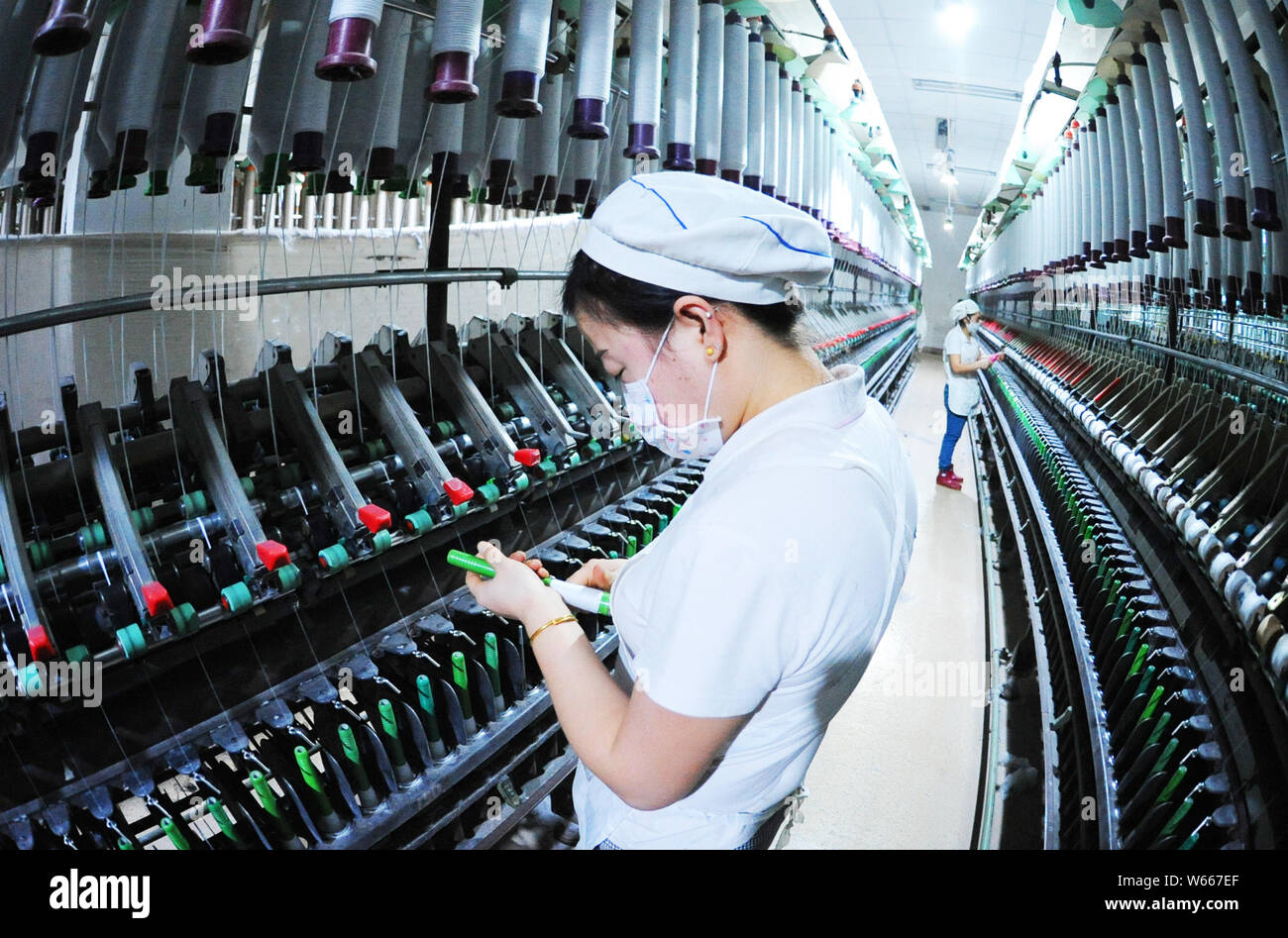 --FILE--Female Chinese workers handle production of yarn at a textile factory in Lianyungang ...