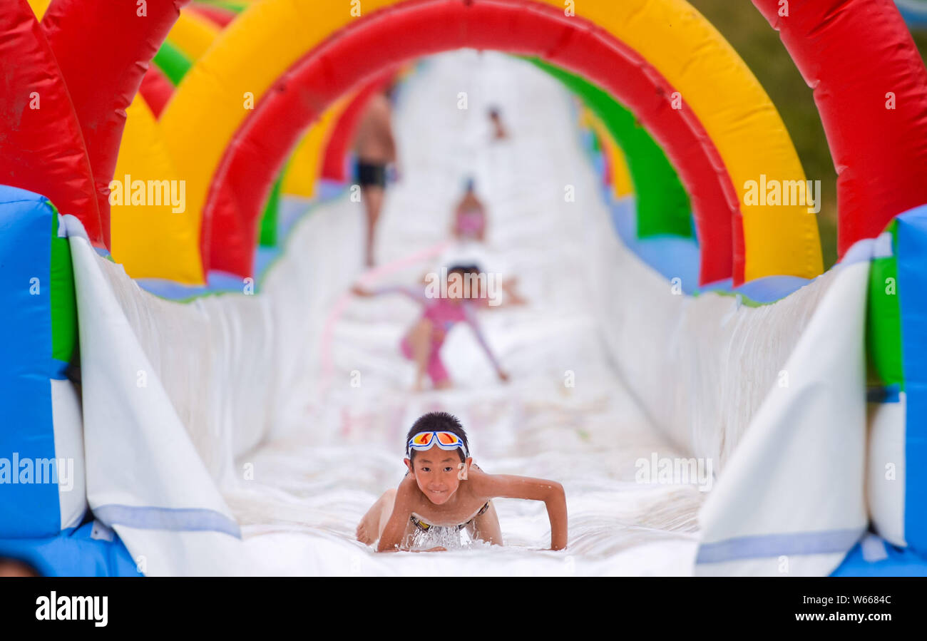 Tourists play on Asia's longest water slide at Jingzhihu Resort in ...