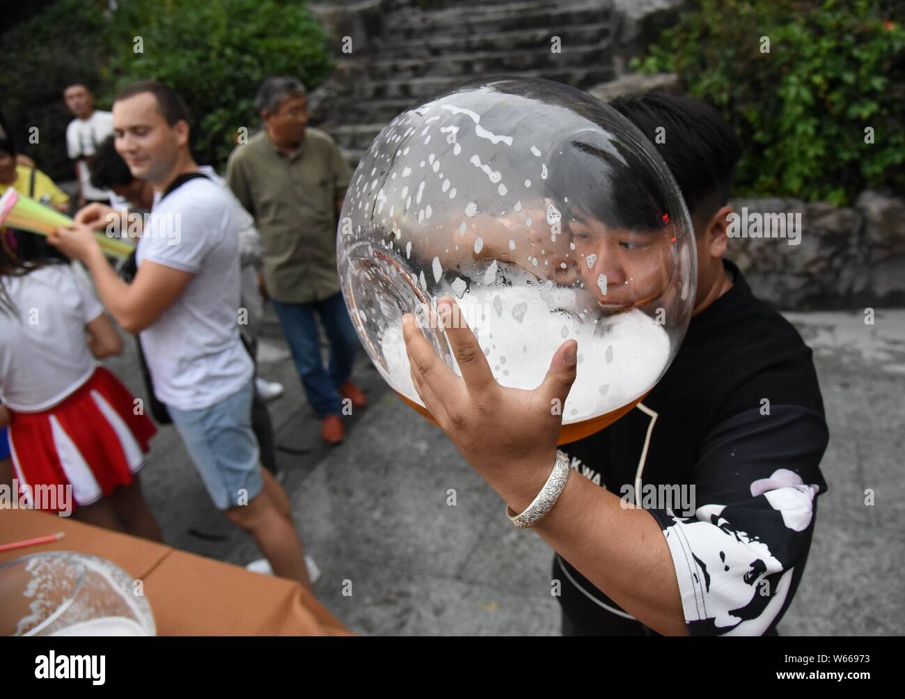 A participate uses a fish tank to drink beer during a beer drinking ...