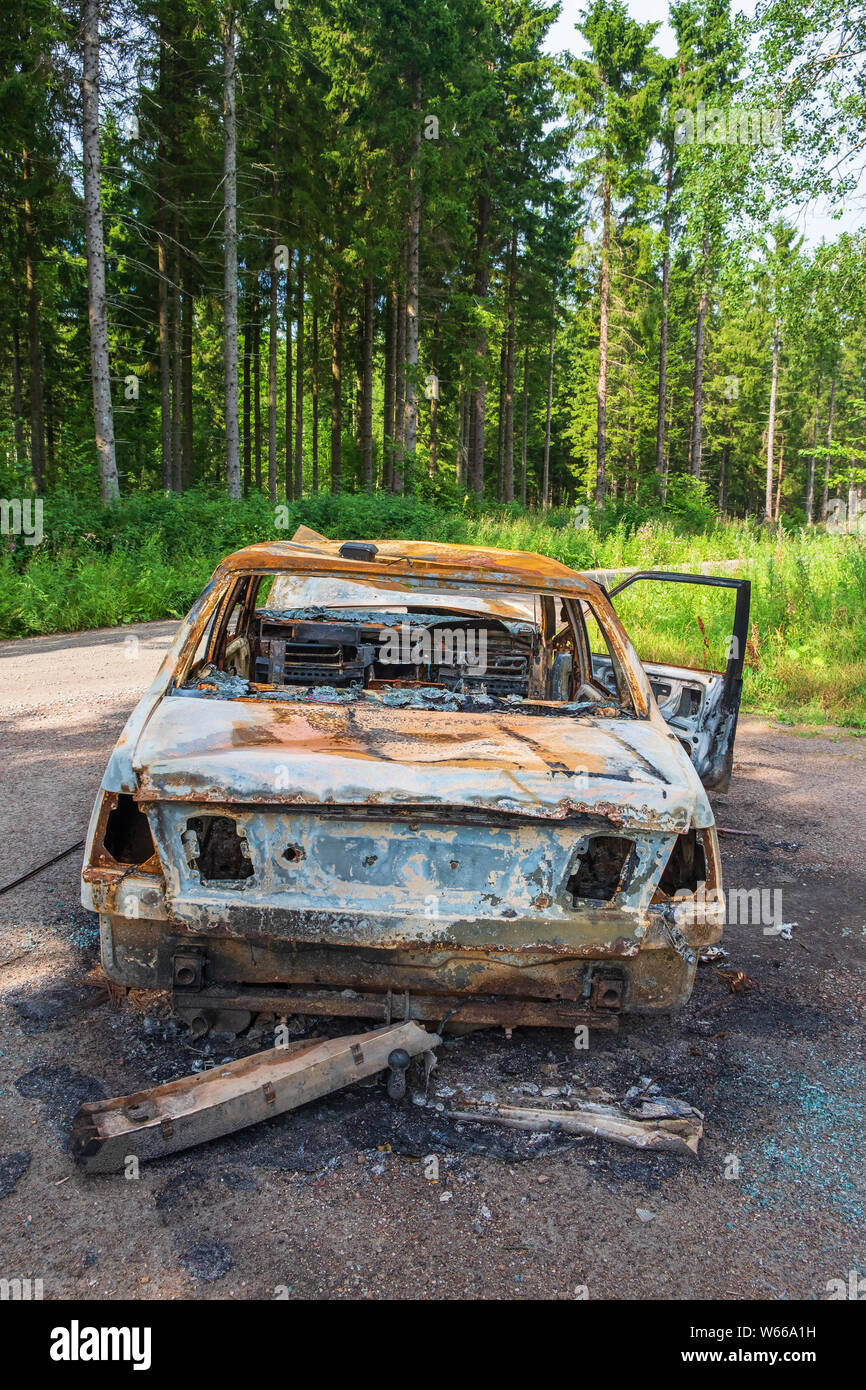 Burned car at a road in the woodland Stock Photo - Alamy