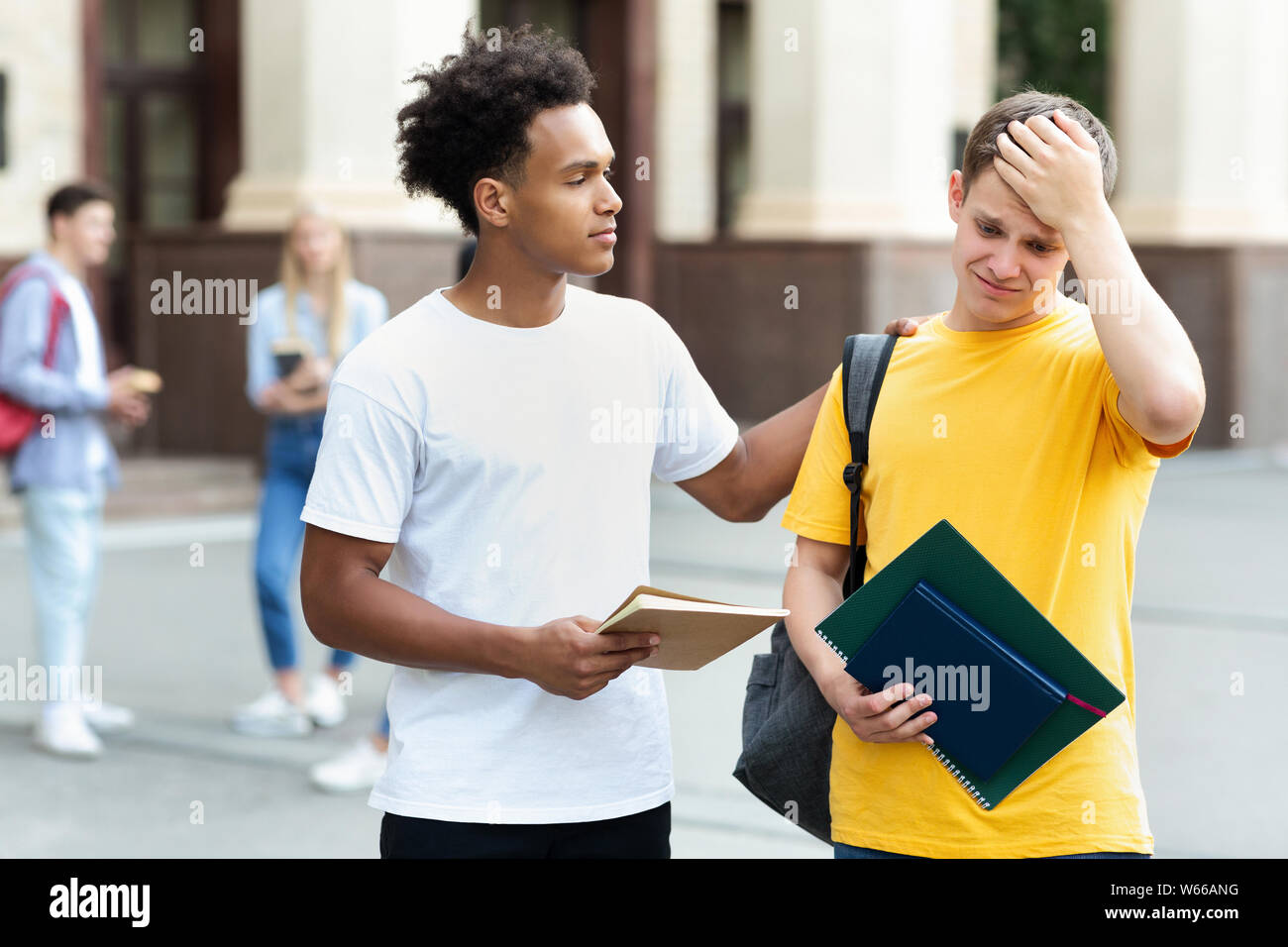 Teenage guy consoling friend over bad exam result Stock Photo - Alamy