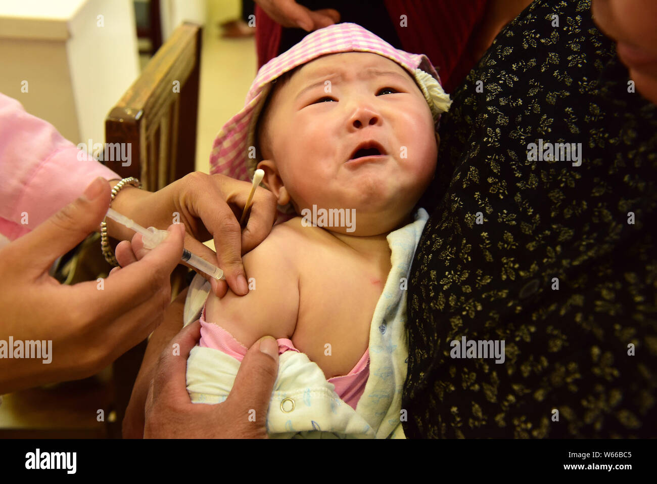 --FILE--A Chinese medical worker vaccinates a baby at a disease control ...