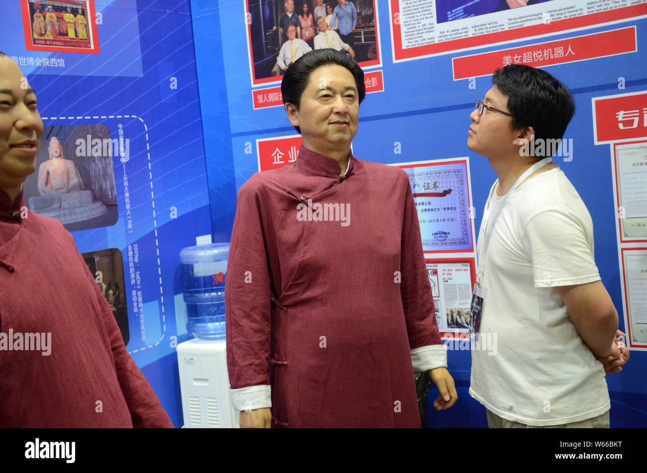 --FILE--A visitor looks at a humanroid robot featuring Chinese ...