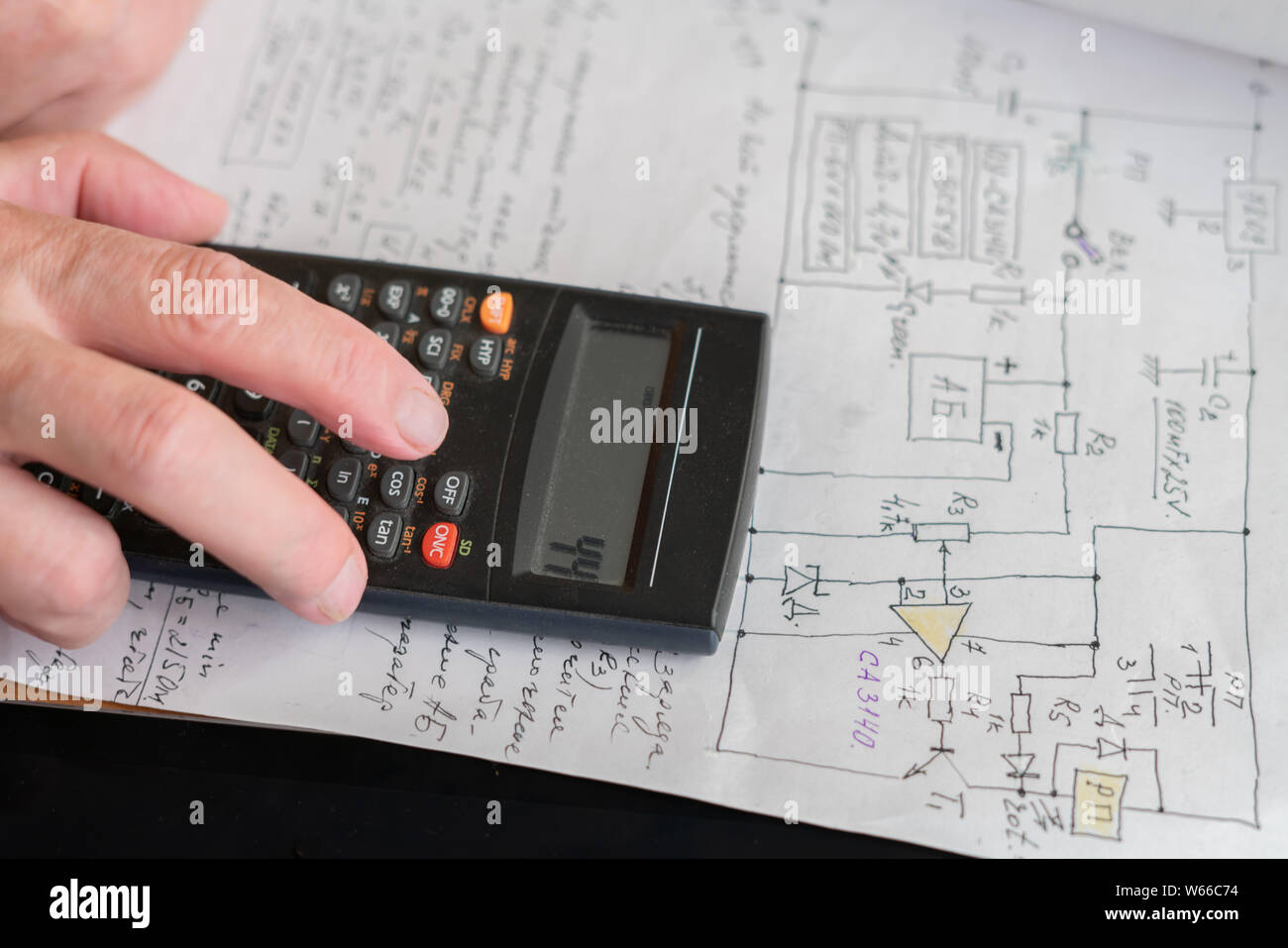 old man doing some math calculations using digital calculator at his ...