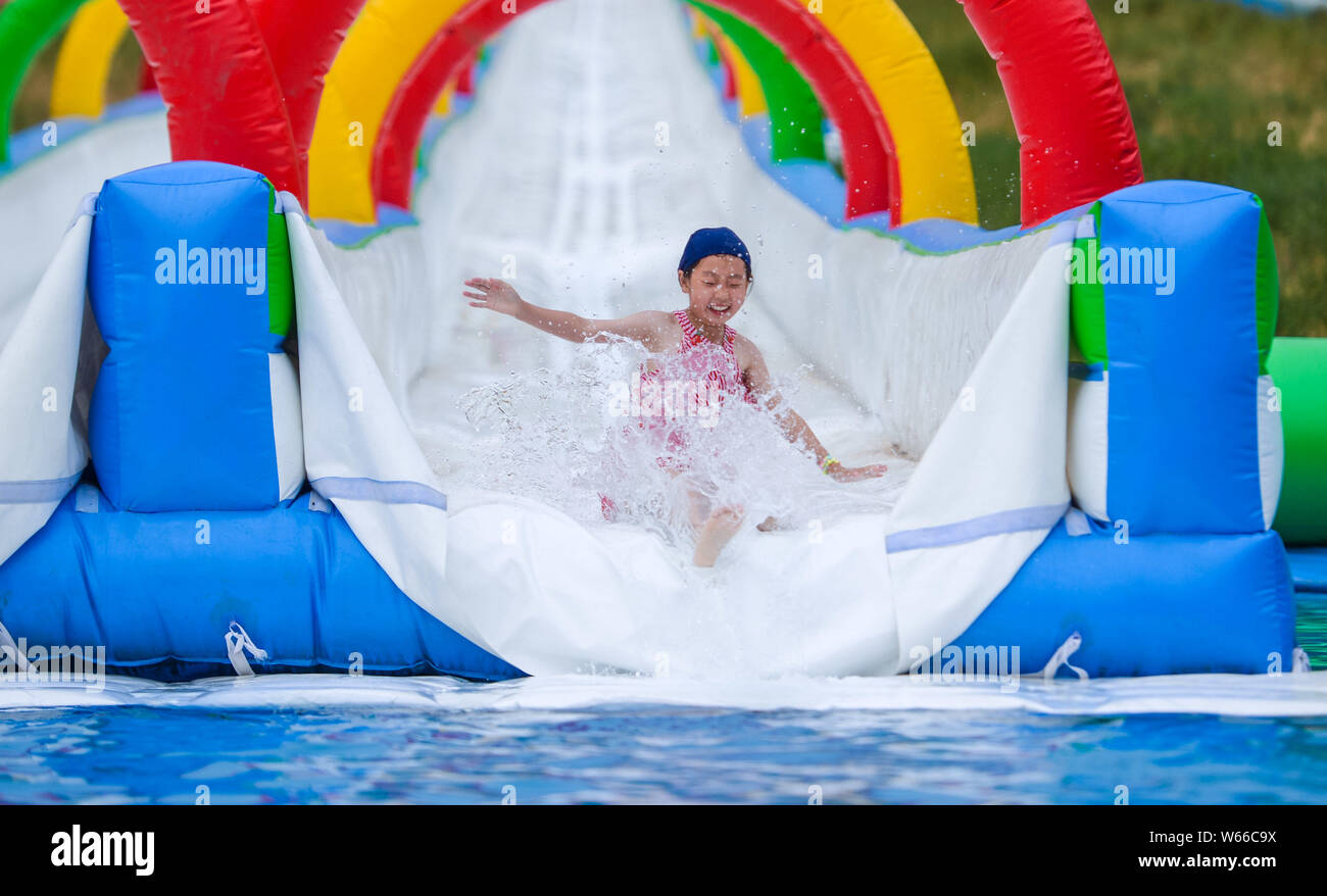 A tourist plays on Asia's longest water slide at Jingzhihu Resort in ...
