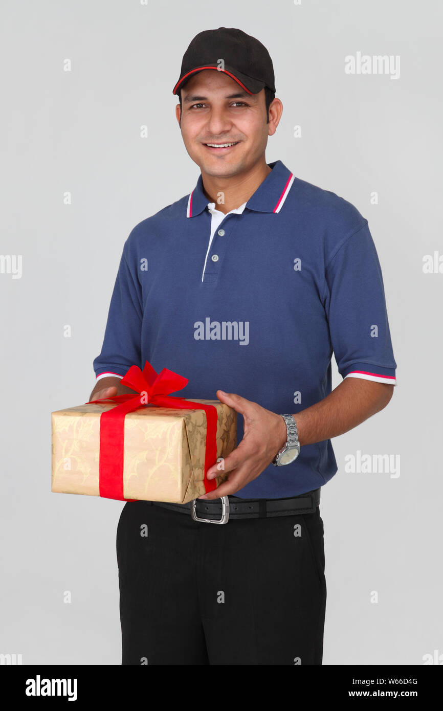 Delivery man delivering parcel Stock Photo - Alamy
