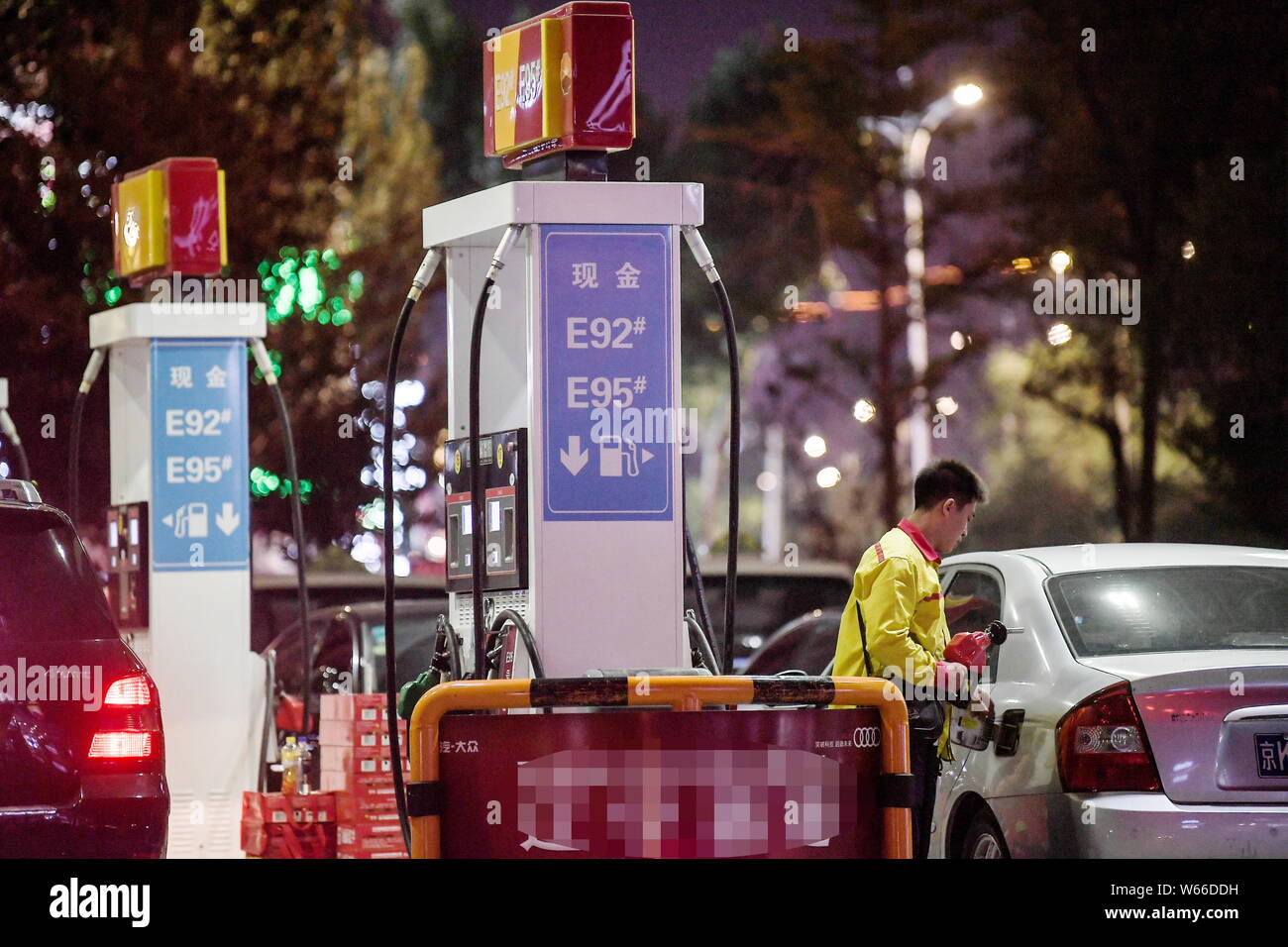 --FILE--A Chinese worker refuels a car at a gas station of CNPC (China ...
