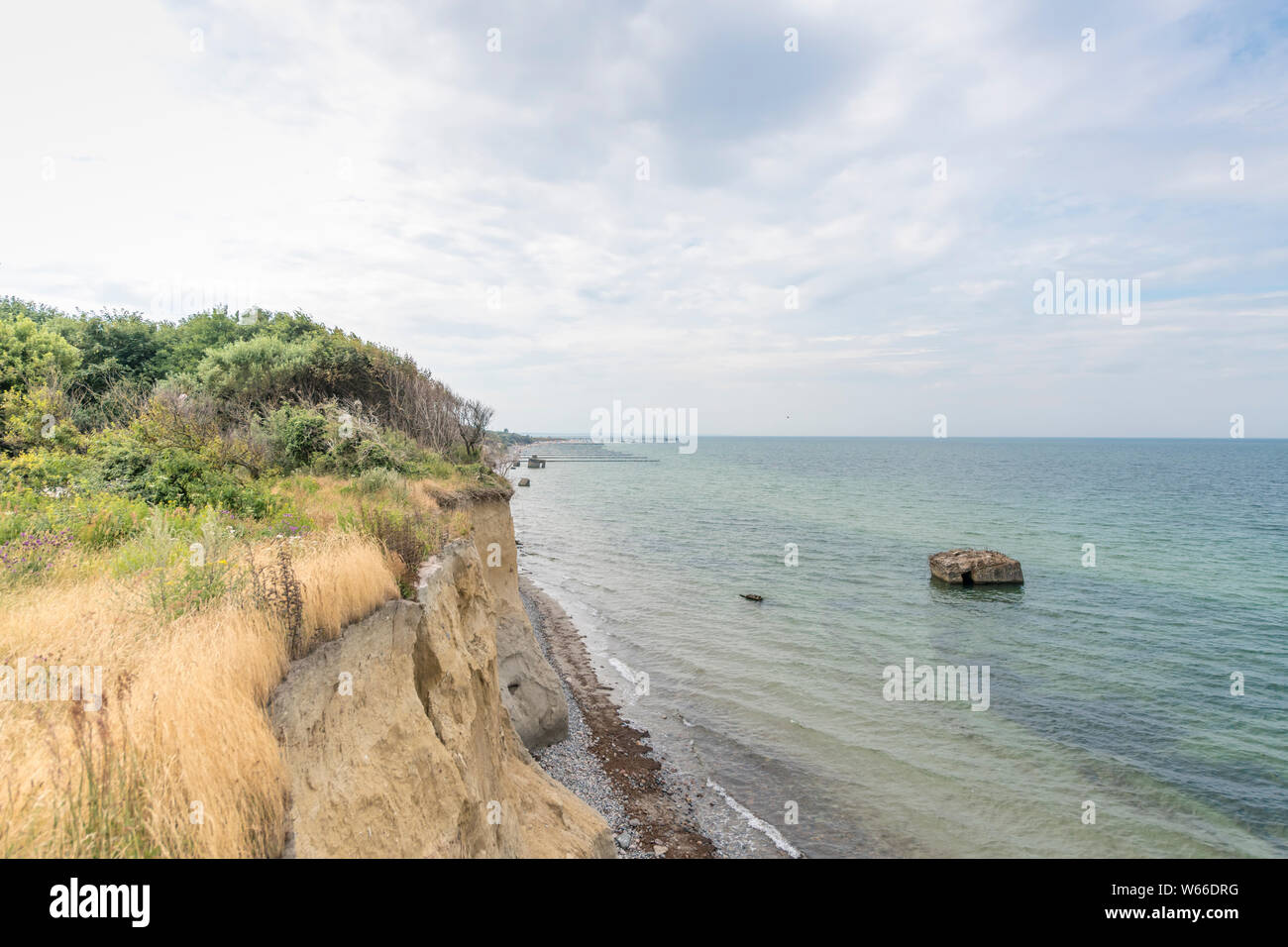 German Baltic Sea coast with sand dunes, grass, water and blue sky ...