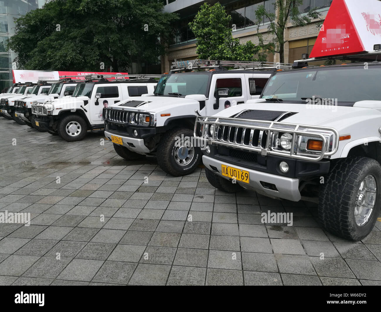 Extended edition Hummer SUVs are lined up in front of an exhibition ...