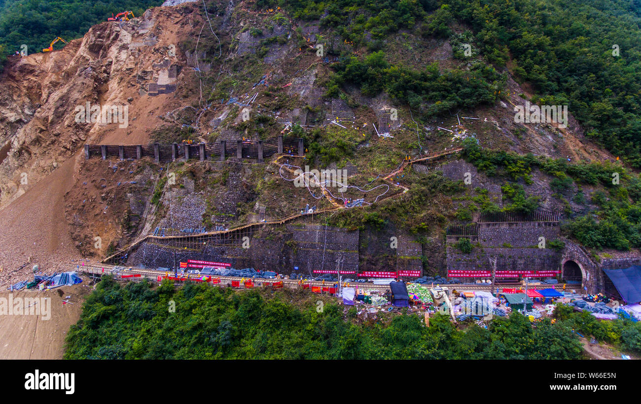 Chinese rescuers clear away mud and stones after the Lueyang section of ...