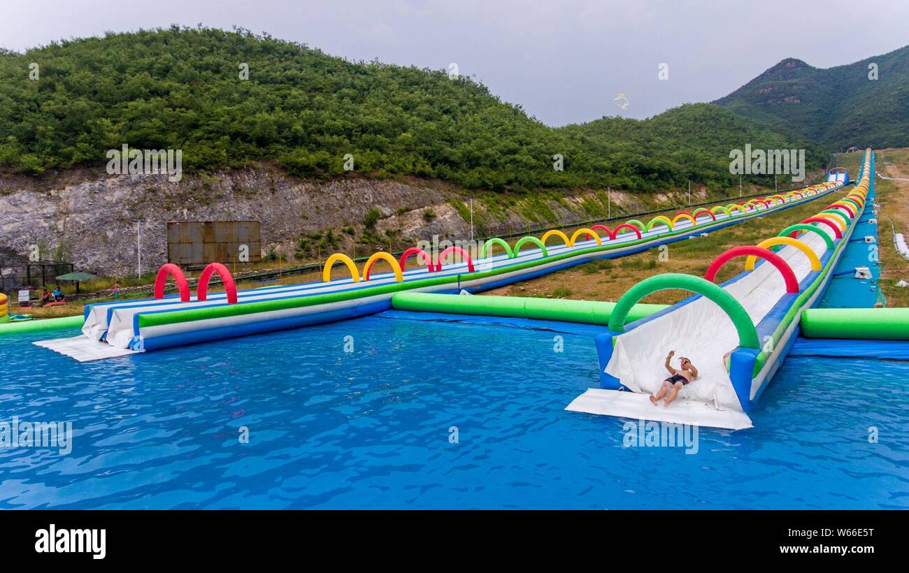 Tourists play on Asia's longest water slide at Jingzhihu Resort in ...