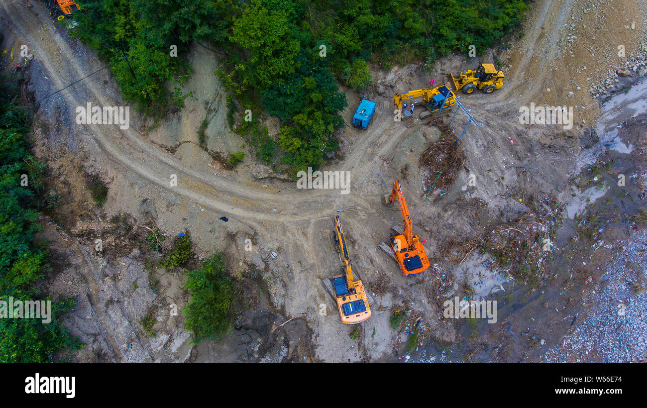 Chinese rescuers clear away mud and stones after the Lueyang section of ...