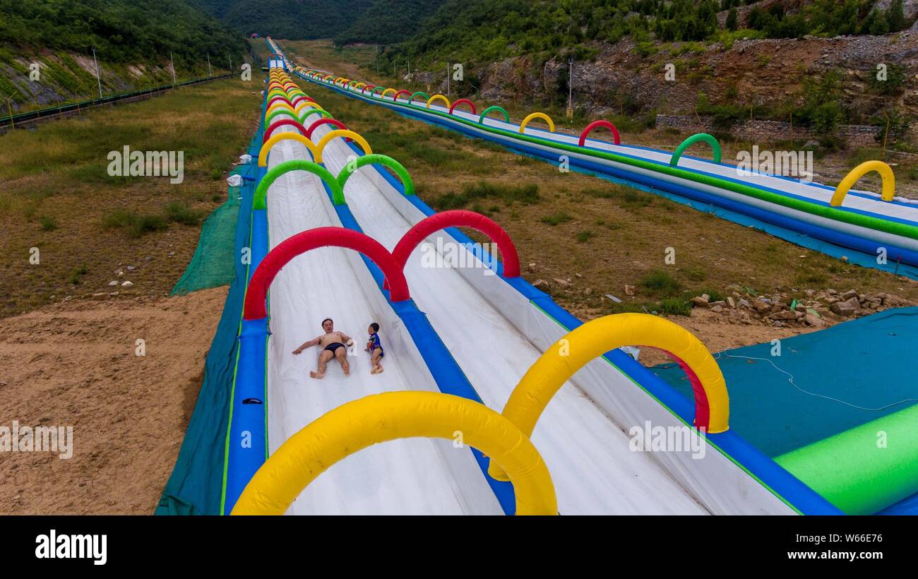 Tourists play on Asia's longest water slide at Jingzhihu Resort in ...