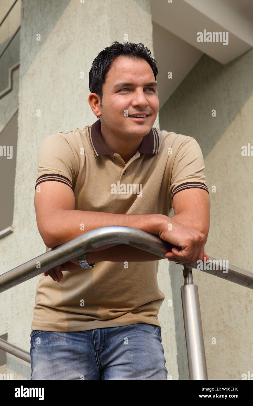 Low angle view of a man leaning against railing Stock Photo - Alamy