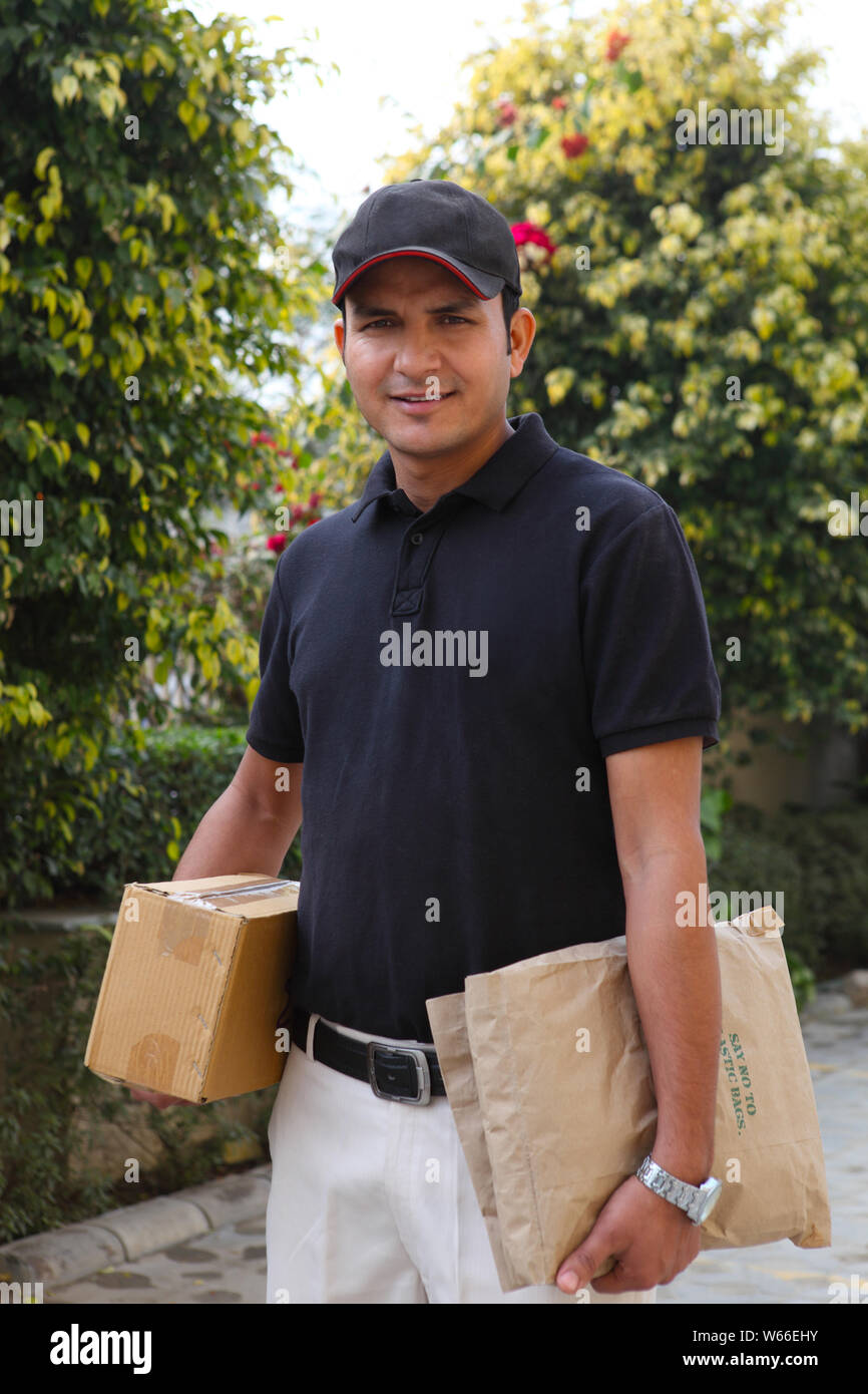 Delivery man delivering parcels Stock Photo - Alamy