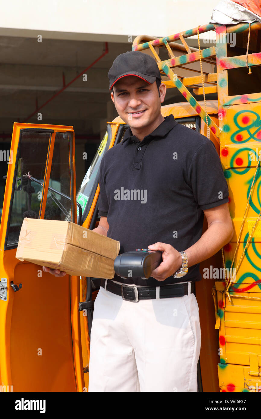Delivery man holding card reader with parcel Stock Photo - Alamy