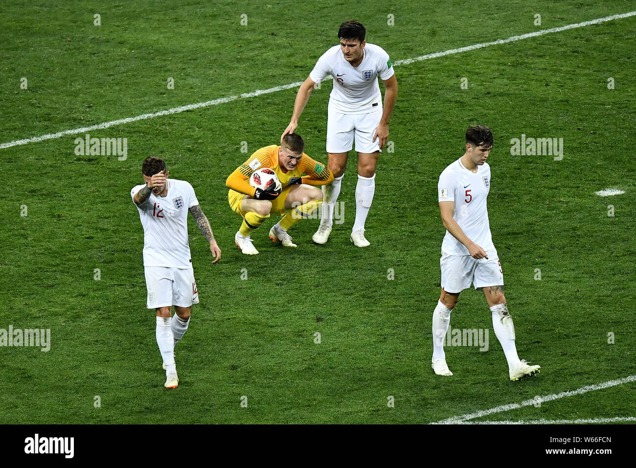 Goalkeeper Jordan Pickford, back left, and teammates of England react ...