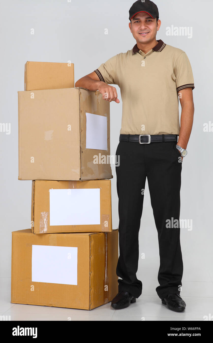 Delivery man standing with parcels Stock Photo - Alamy