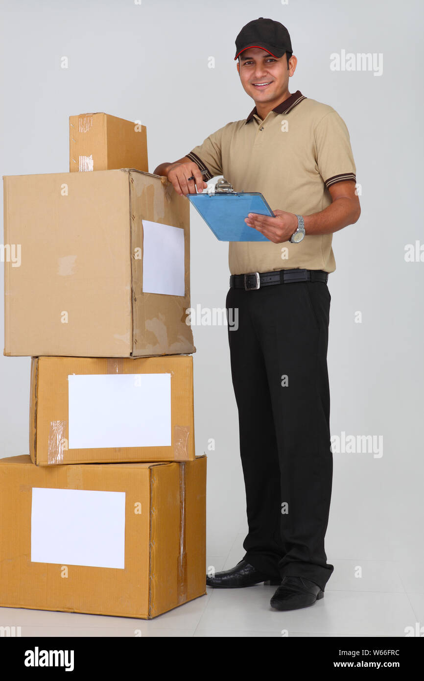 Delivery man standing with parcels Stock Photo - Alamy