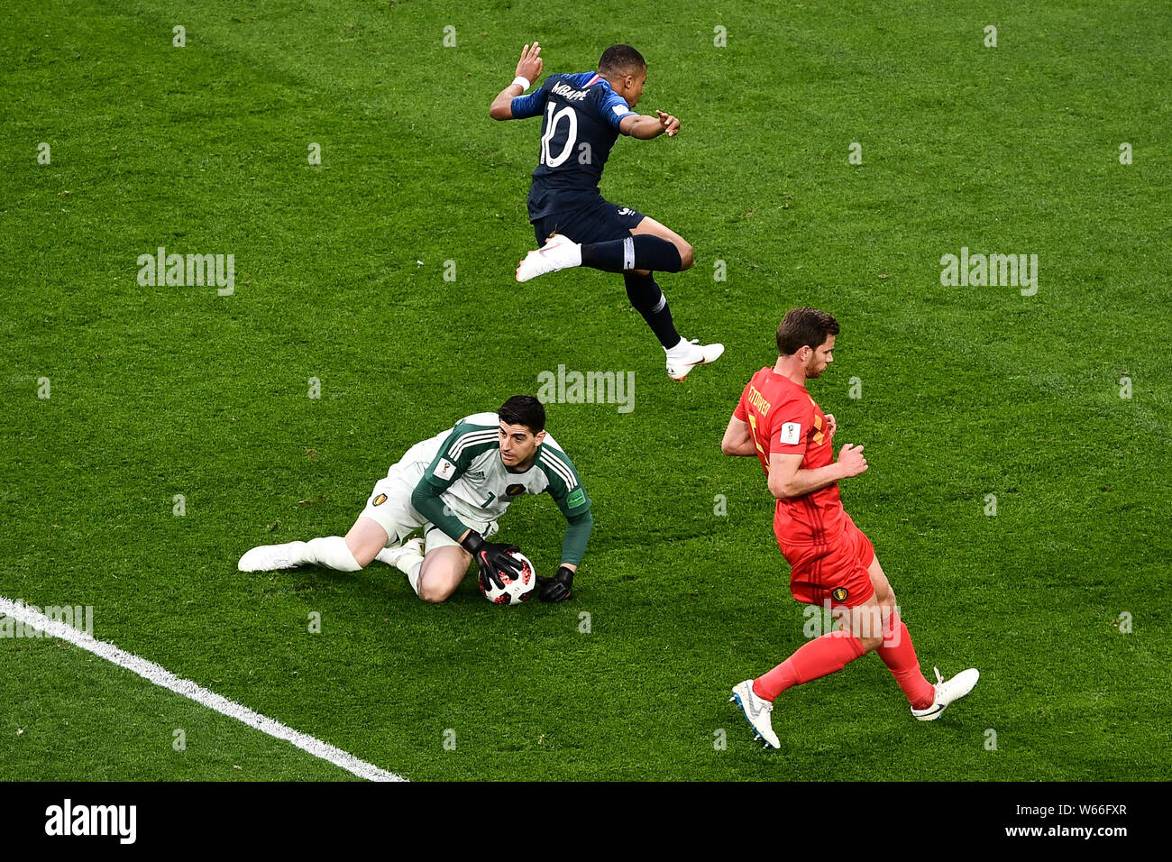 Kylian Mbappe of France, top, jumps over goalkeeper Thibaut Courtois of ...