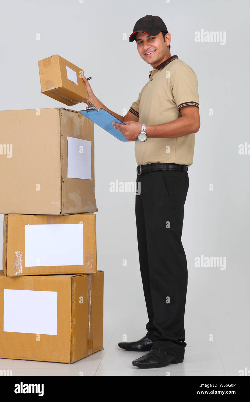 Delivery man standing with parcels Stock Photo - Alamy
