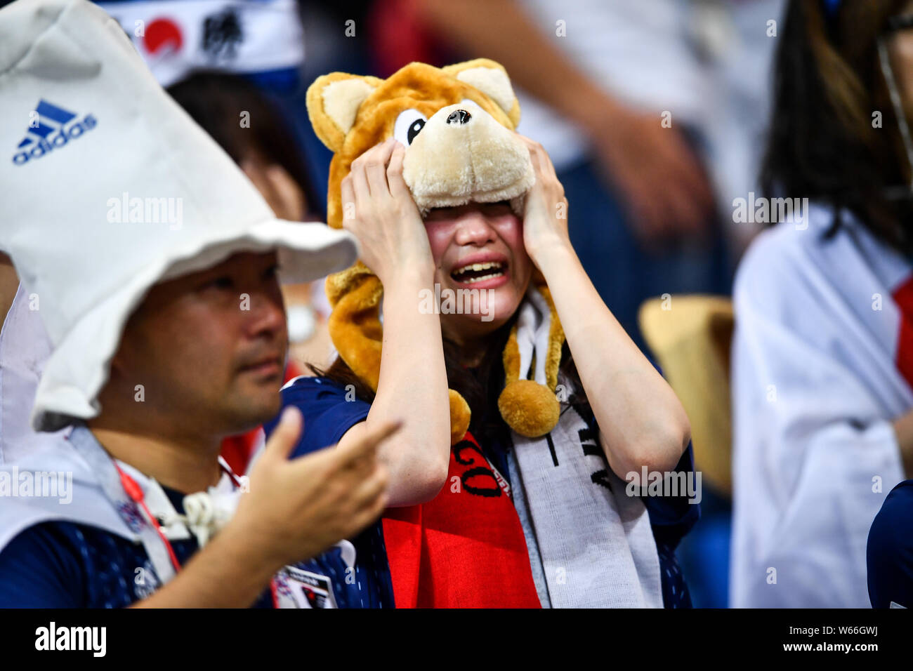 A heartbroken Japanese fan weeps after Japan was defeated by Belgium in ...