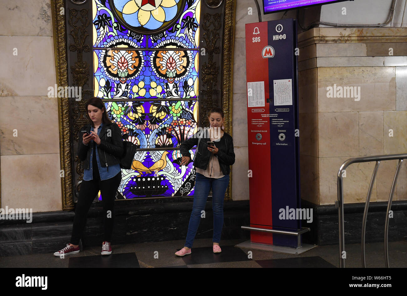 Commuters use their smartphones in a subway station of the Moscow Metro ...