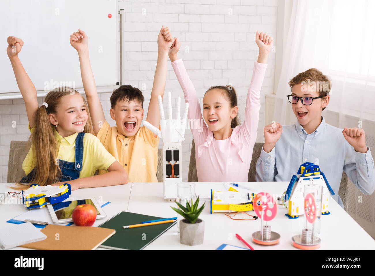 Children celebrating success after doing robots at lesson Stock Photo ...
