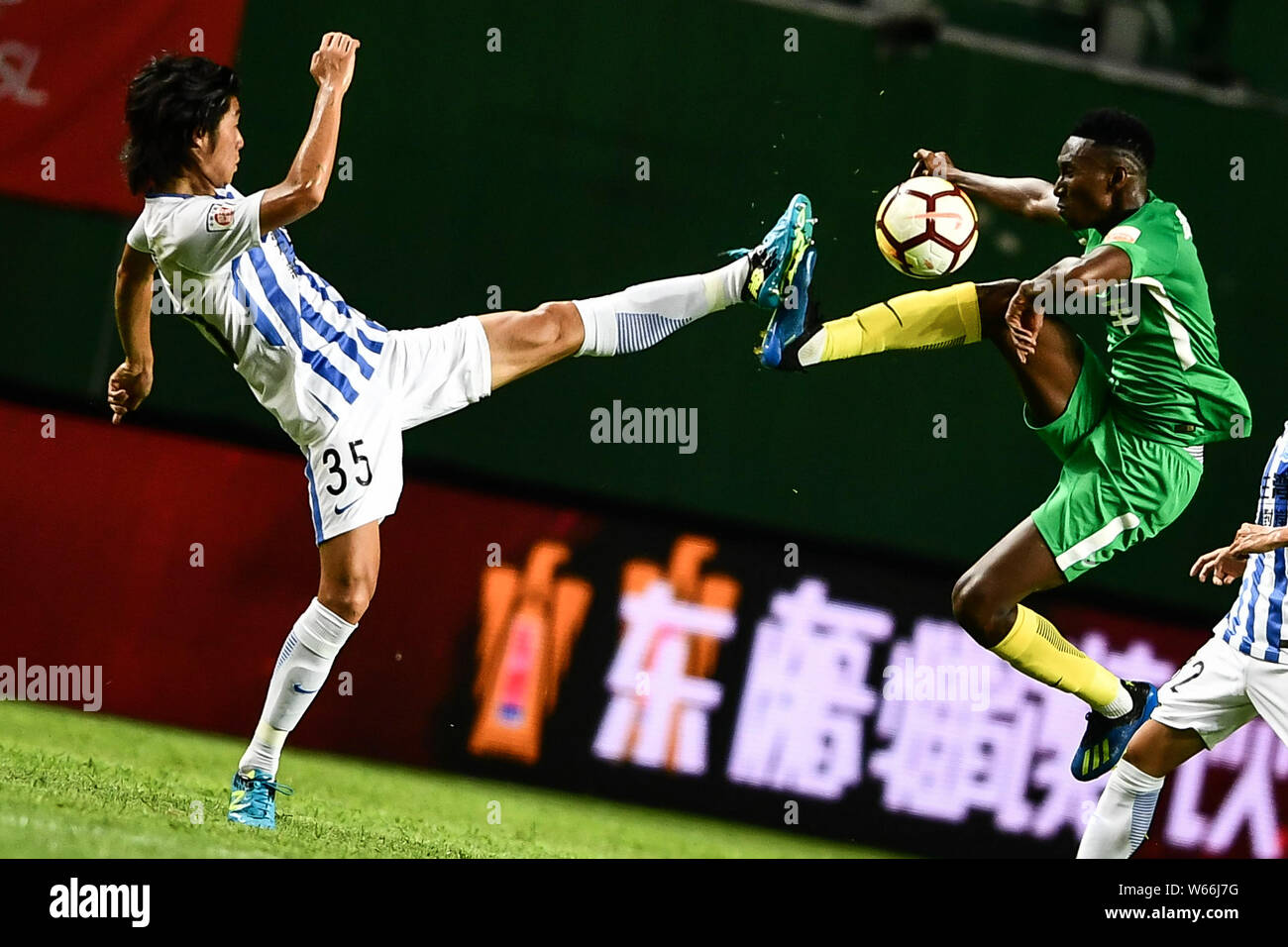 Li Tixiang of Guangzhou R&F, left, challenges Gambian football player ...