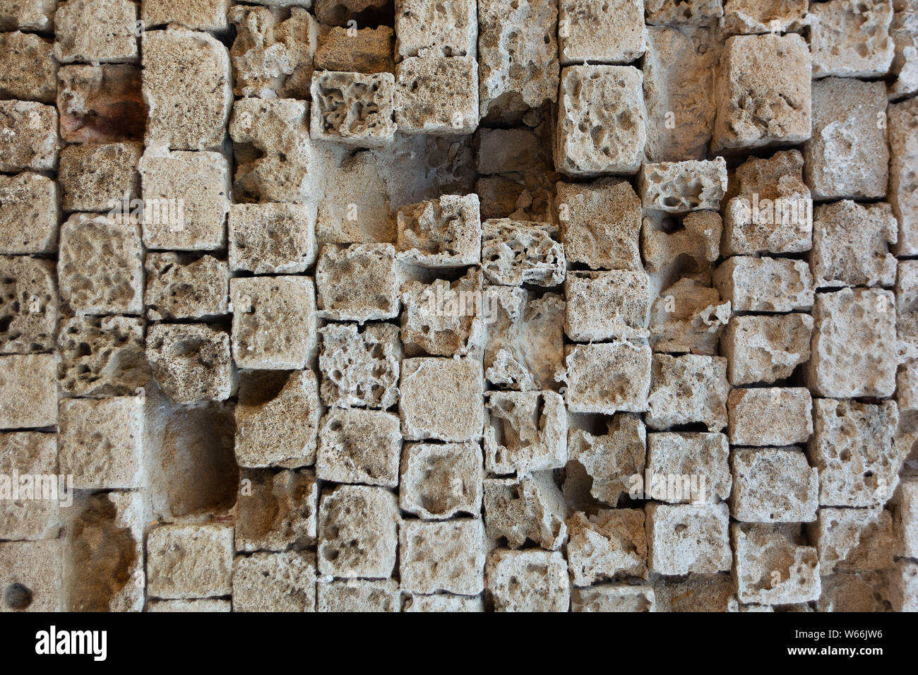 Partially destroyed masonry wall of old stone blocks of limestone ...
