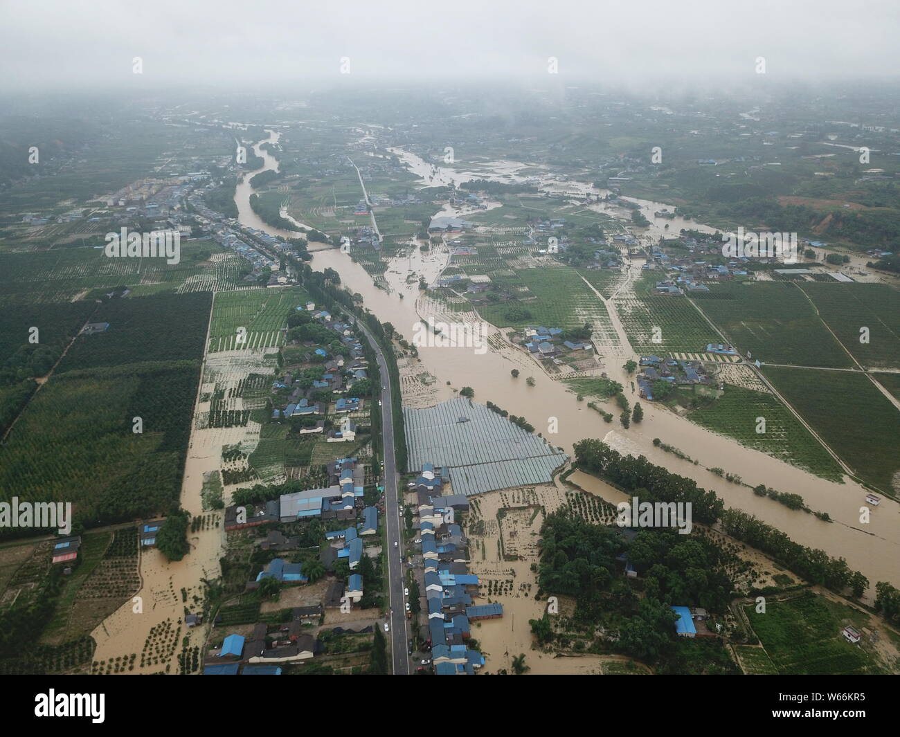 An aerial view of residential houses and fields submerged by floodwater ...