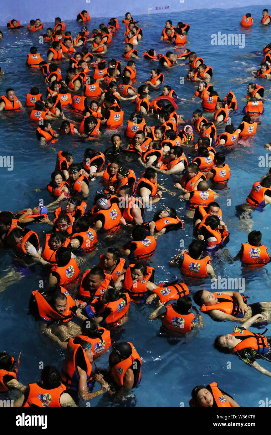 Aerial view of a swimming pool crammed with Chinese holidaymakers on a ...