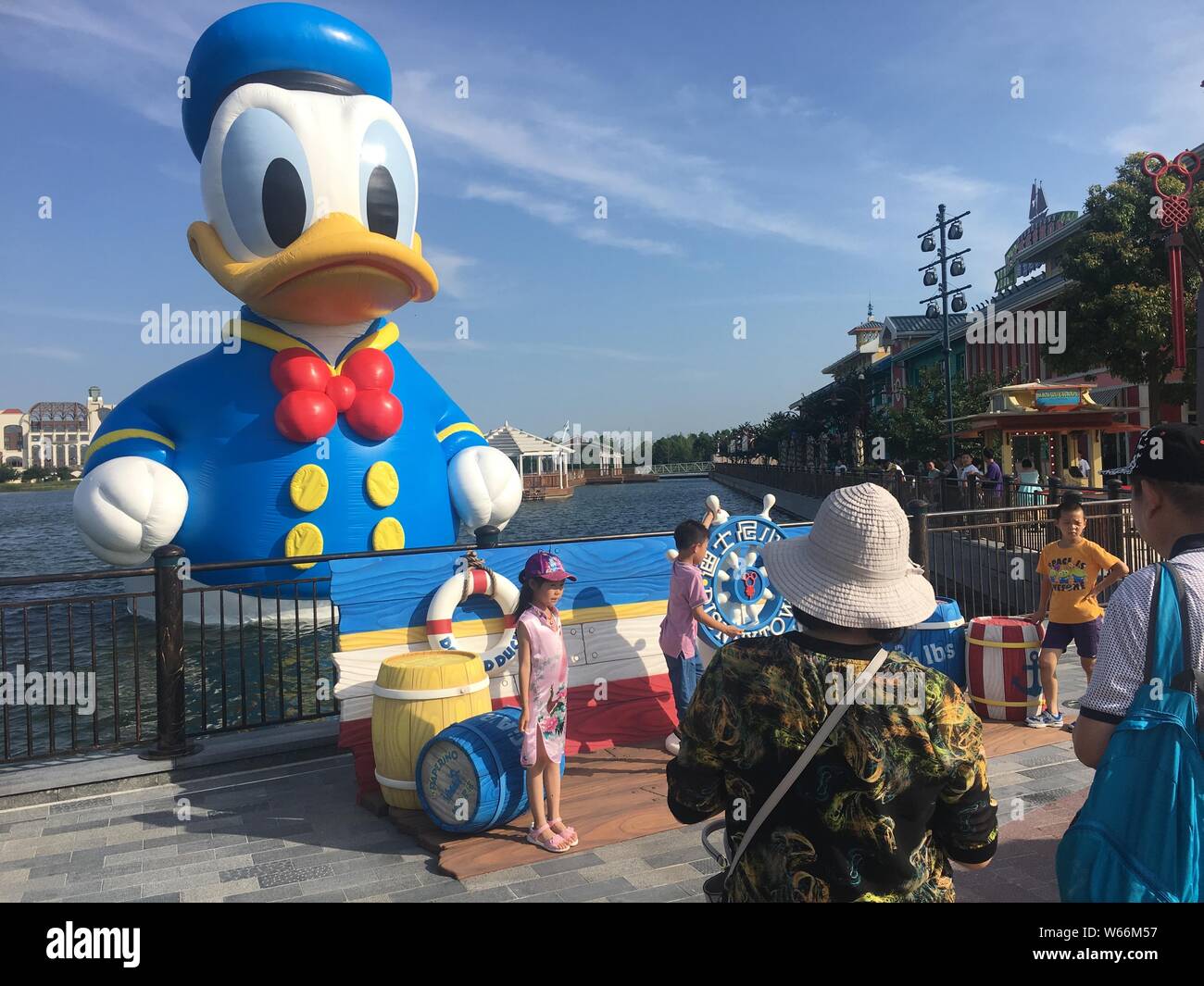 Tourists pose for photos with an 11-meter-tall inflatable Donald Duck ...