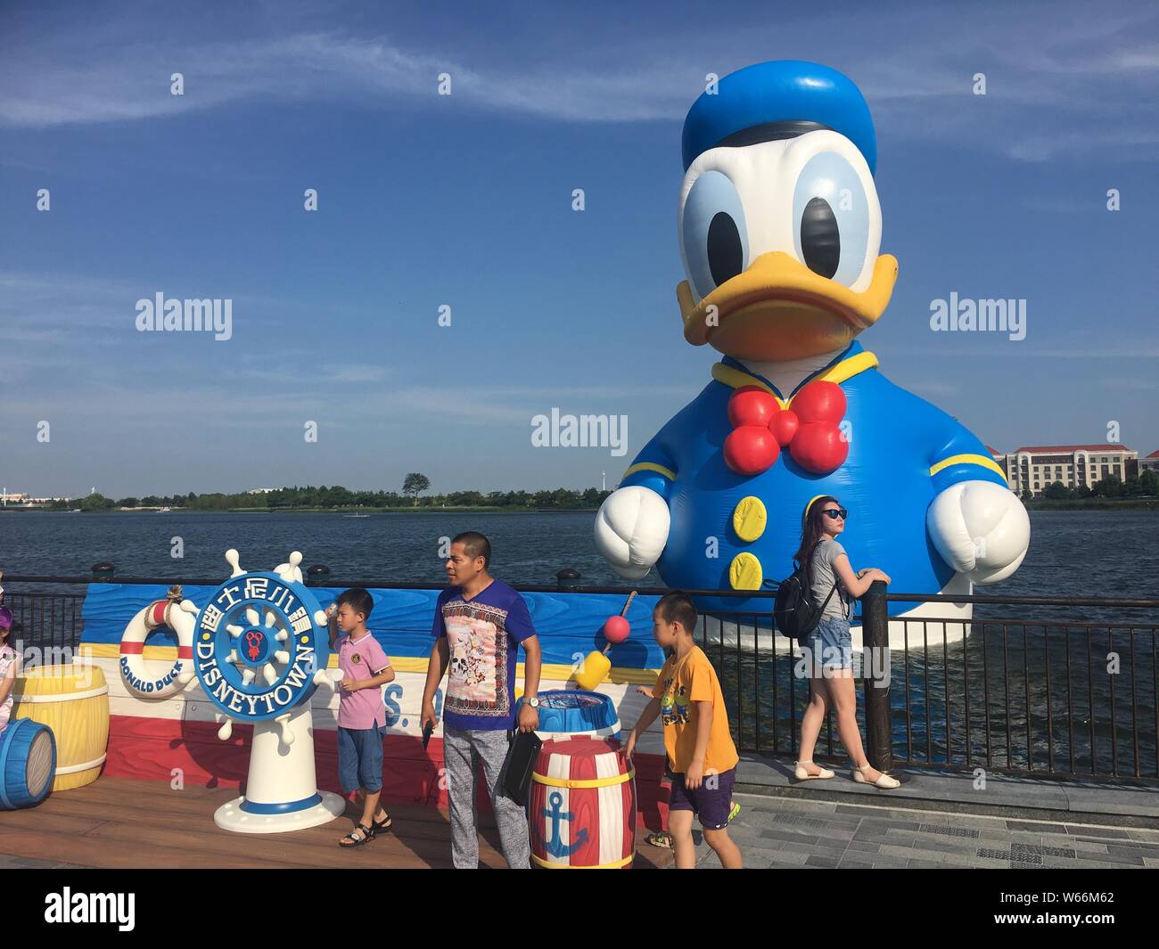 Tourists pose for photos with an 11-meter-tall inflatable Donald Duck ...