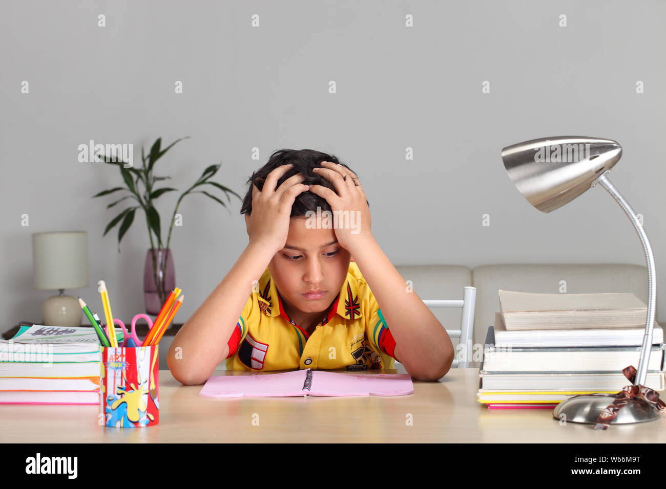 Boy reading a book and looking stressed Stock Photo - Alamy