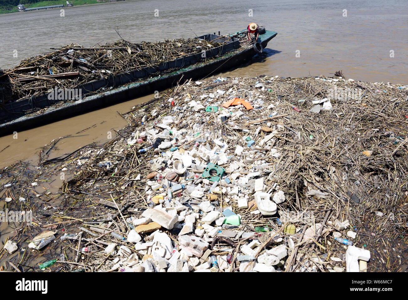 A Chinese worker collects garbage floating on the Yangtze River in ...