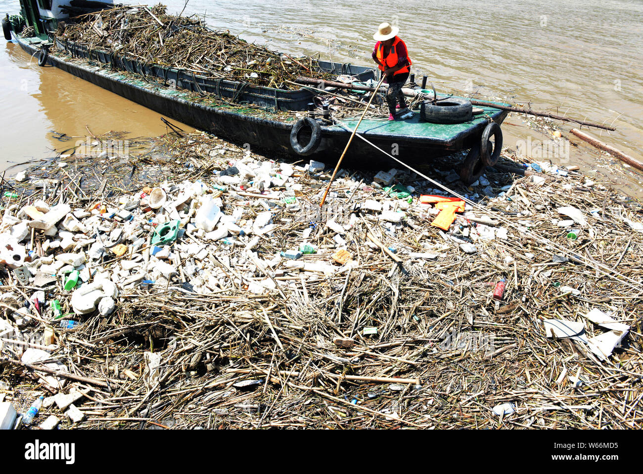 A Chinese worker collects garbage floating on the Yangtze River in ...