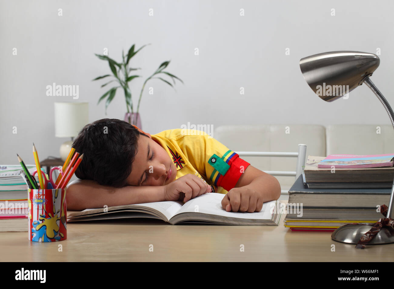 Boy napping on a desk in a study room Stock Photo - Alamy