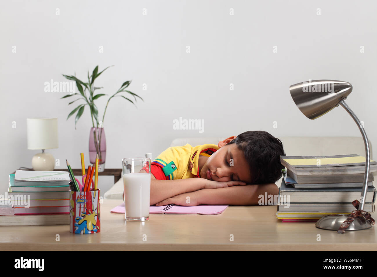 Boy napping on a desk in a study room Stock Photo - Alamy