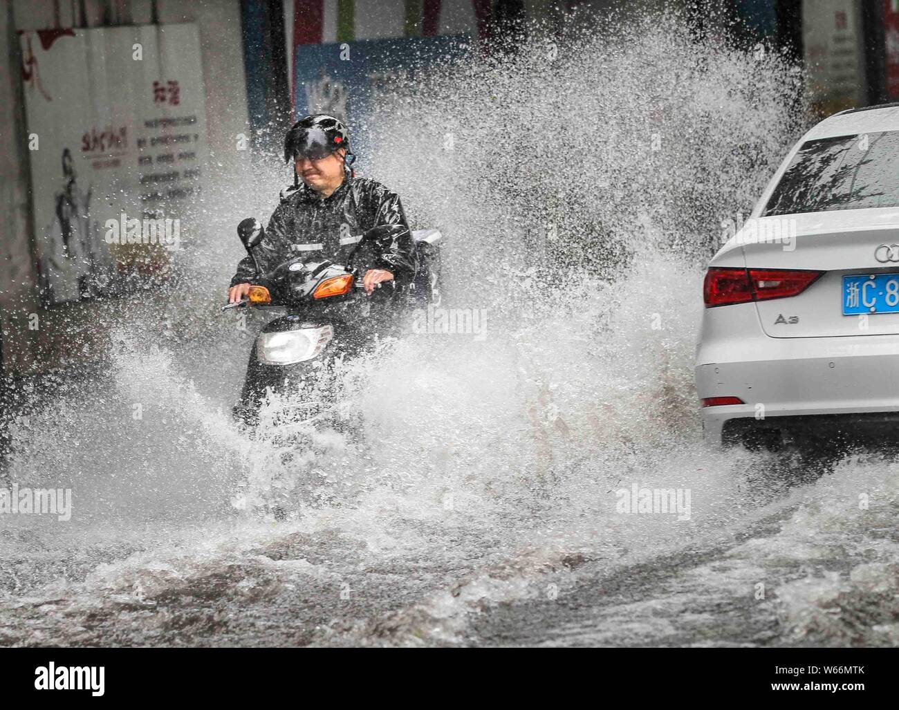 A cyclist rides on a flooded road after heavy rainstorm and strong wind ...
