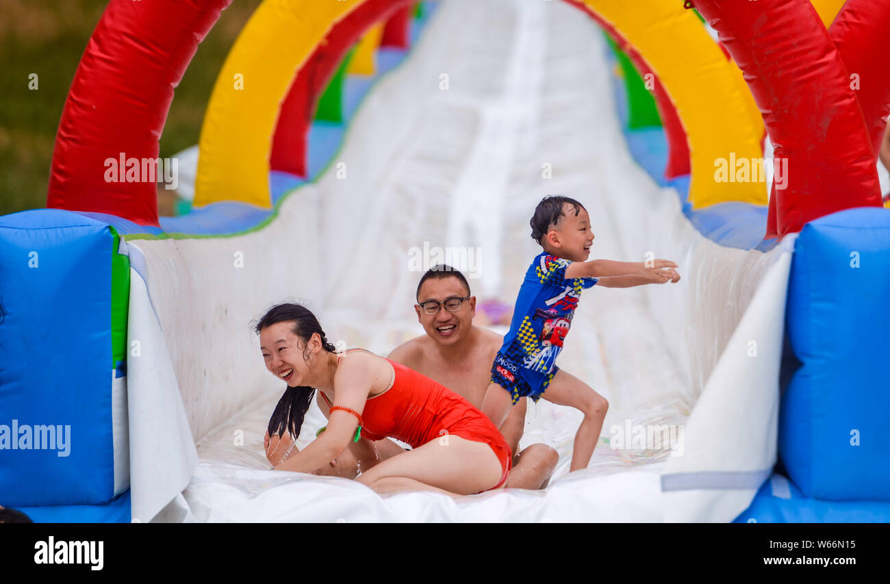 Tourists play on Asia's longest water slide at Jingzhihu Resort in ...