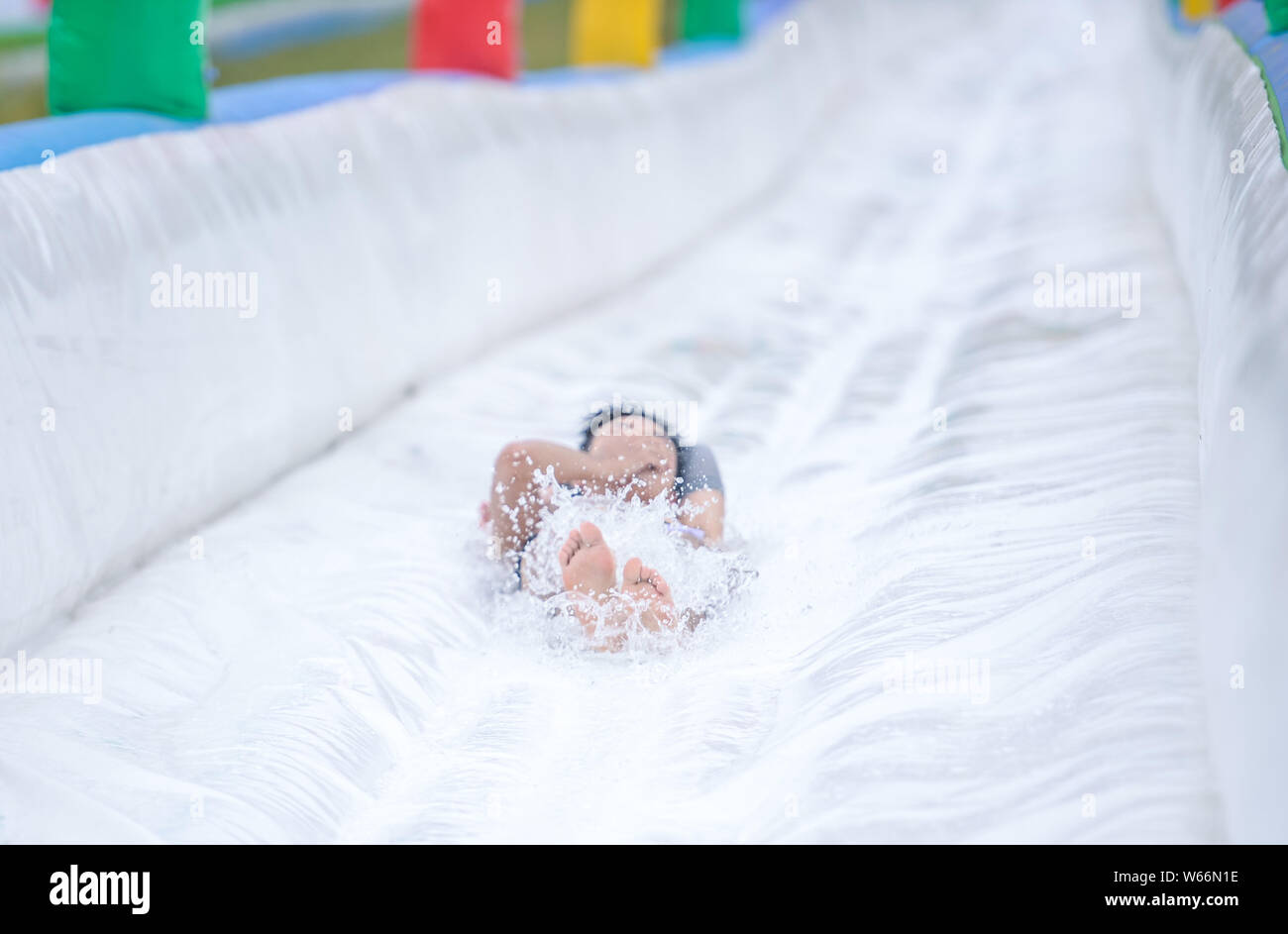 A tourist plays on Asia's longest water slide at Jingzhihu Resort in ...