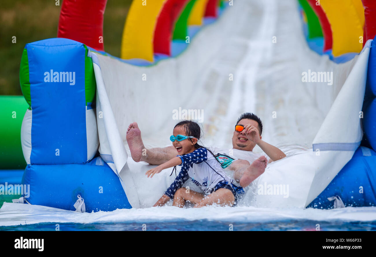 Tourists play on Asia's longest water slide at Jingzhihu Resort in ...