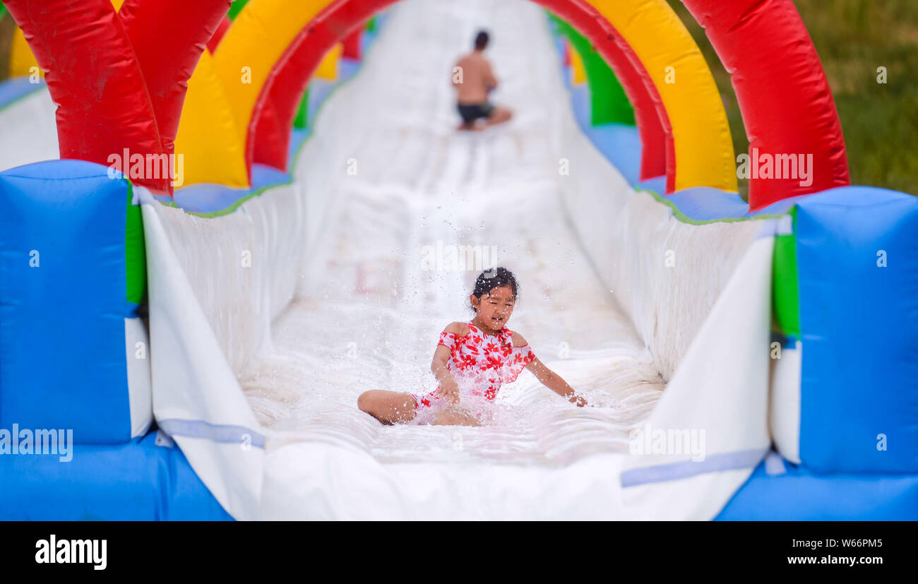 Tourists play on Asia's longest water slide at Jingzhihu Resort in ...
