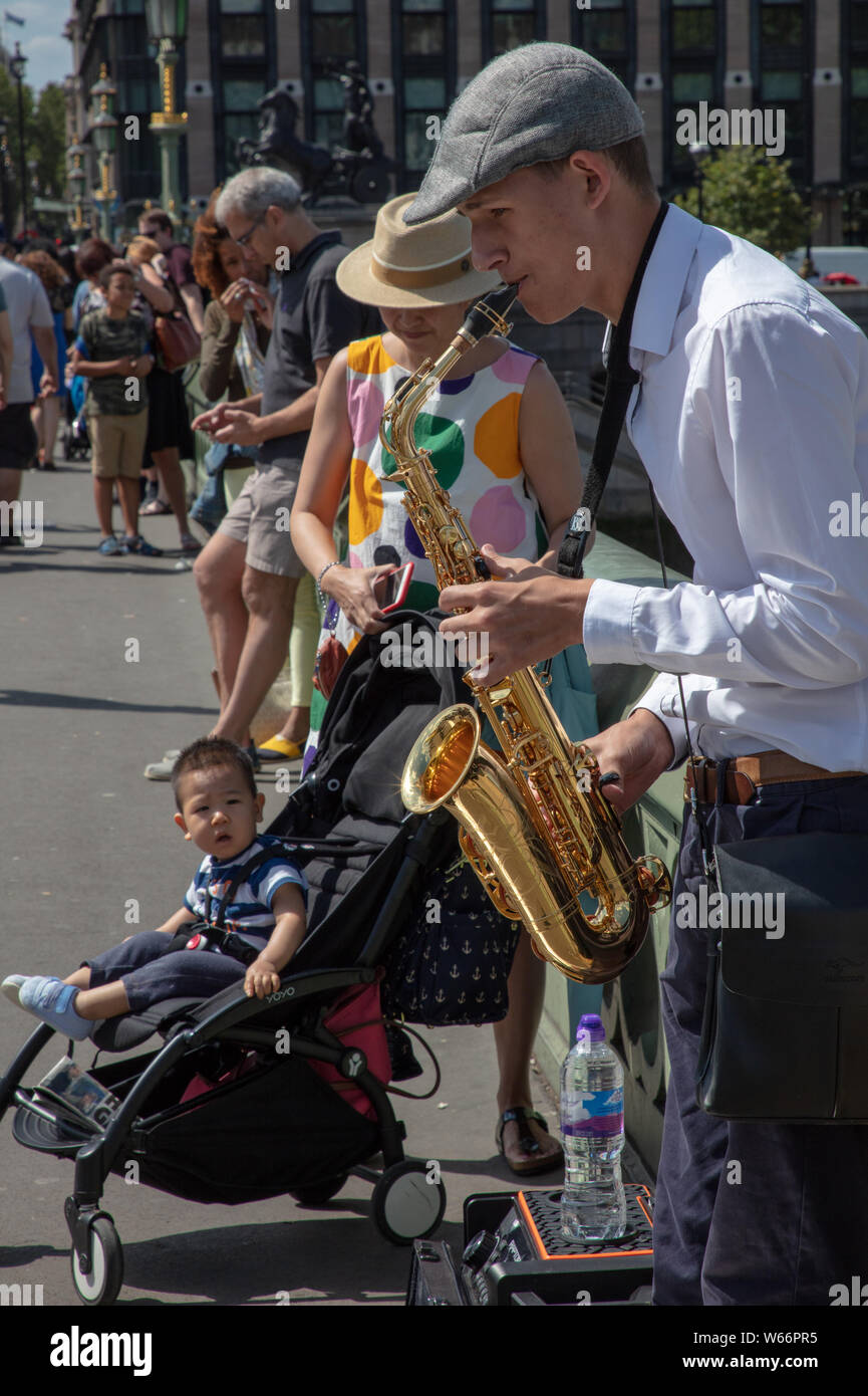 Toddler in a pushchair is completely absorbed by the sound of the ...
