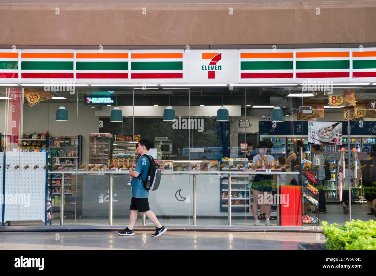 --FILE--A pedestrian walks past a 7-Eleven convenience store in ...